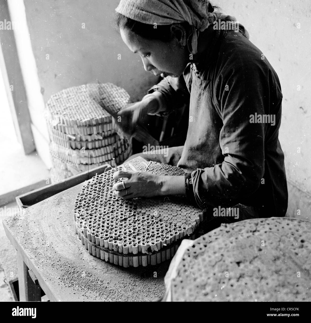 Hong Kong,1950s. Female Chinese worker making a firework by hand, by ...