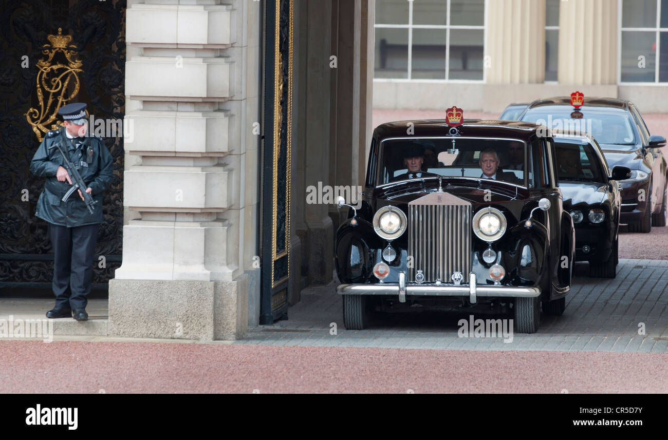 An armed Police officer watching the car of Her Majesty Queen Elizabeth ...