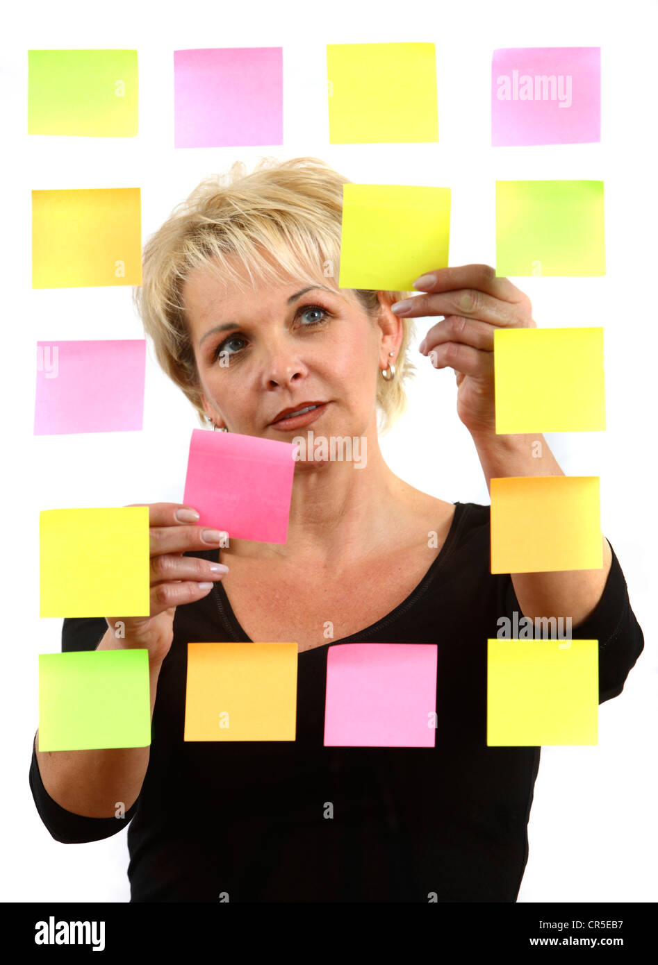 Woman Sticks Self adhesive Post It Paper Notes Stuck To A Pane Of Glass Different Colors woman-sticks-self-adhesive-post-it-paper-notes-stuck-to-a-pane-of-glass-different-colors