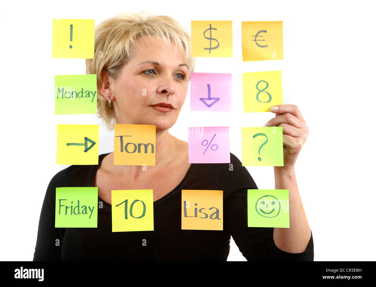 woman sticks self-adhesive Post It, paper notes, stuck to a pane of ...