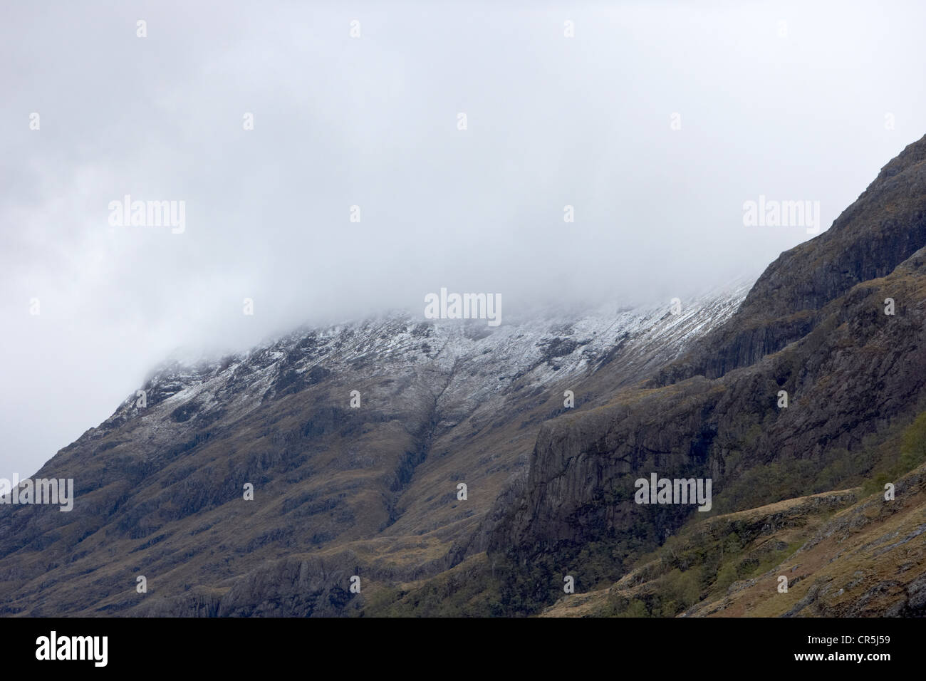 snow capped mountains covered in scotch mist in the aonach eagach ridge ...