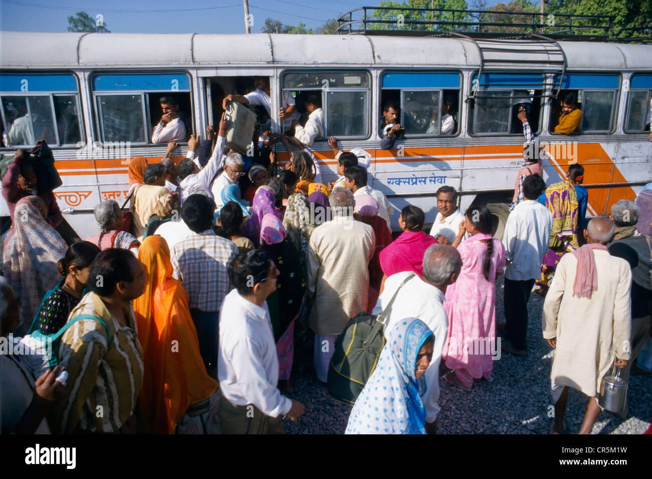 People trying to enter an already overloaded public bus in Bhuj ...