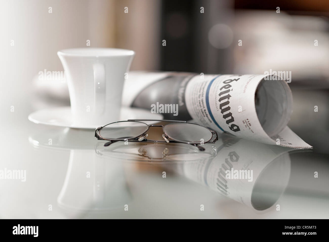 Still life with a daily newspaper, a pair of glasses and a coffee cup ...