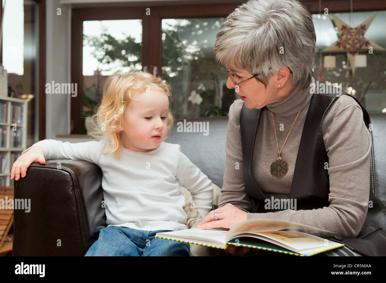 Grandmother reading a book to her granddaughter Stock Photo - Alamy