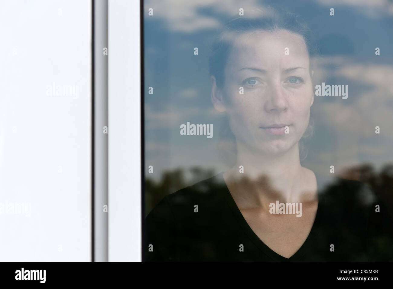 Young woman behind a window, portrait Stock Photo - Alamy