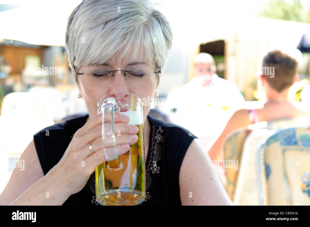 Woman drinking a beer with eyes closed Stock Photo - Alamy