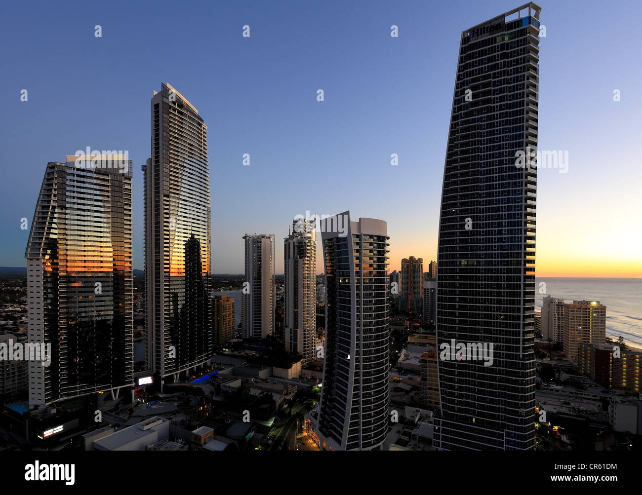 Residential towers stand at sunrise showing a reflection of the city ...