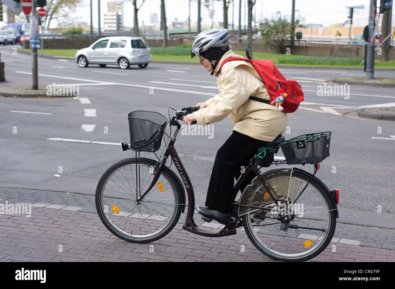 Woman riding her cycle on a cycle path in the city of Cologne Germany ...