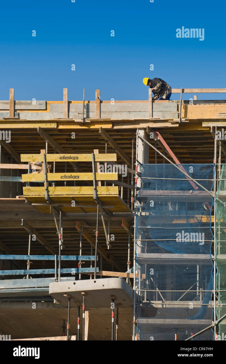 Construction industry, workers with boarding on top of a building site ...