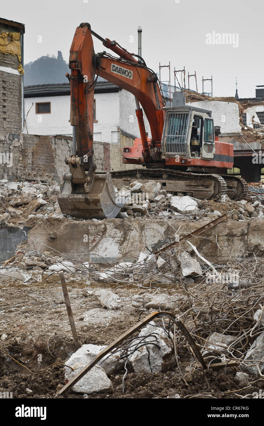 House demolition, excavator on building site, blocks of concrete and ...
