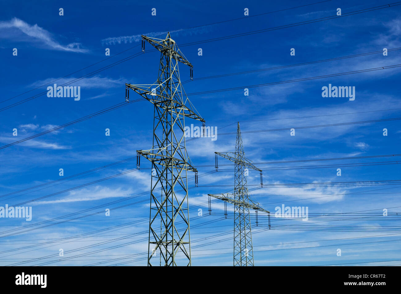 Two electricity pylons against blue sky with cirrostratus clouds Stock ...