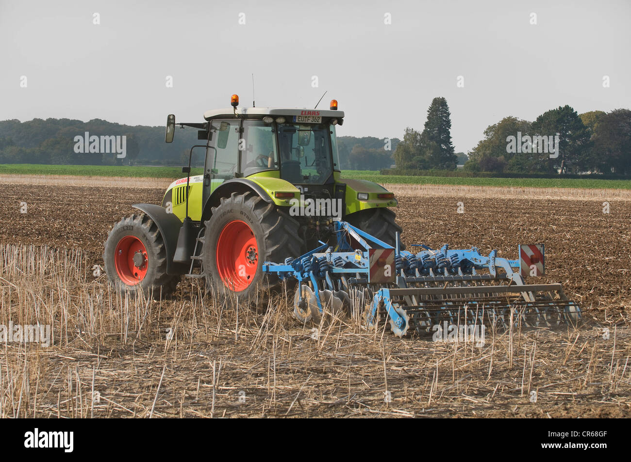 Tractor with a cultivator driving on a field, PublicGround Stock Photo ...