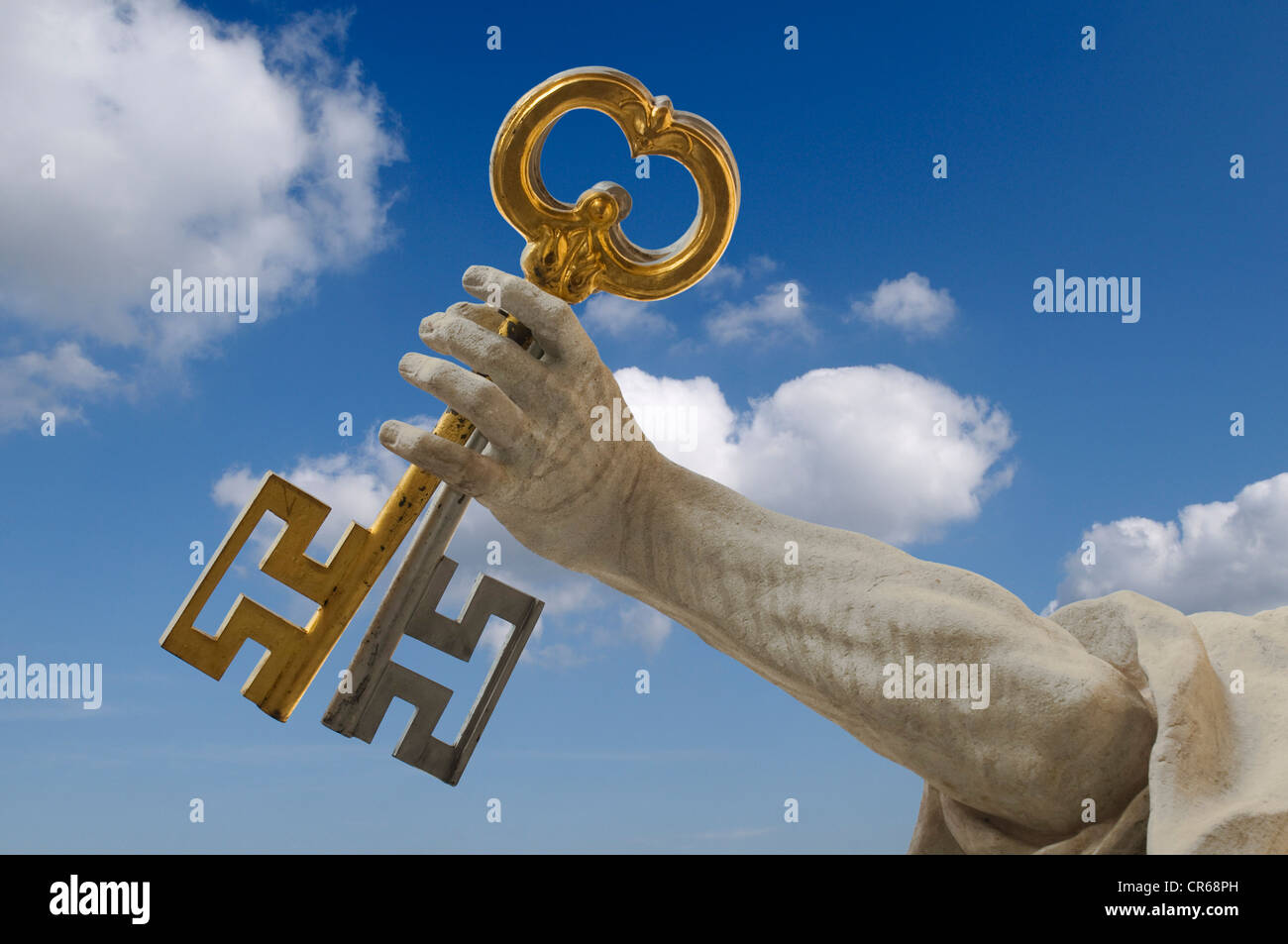 Arm of St. Peter with the key of heaven in front of a cloudy blue sky ...