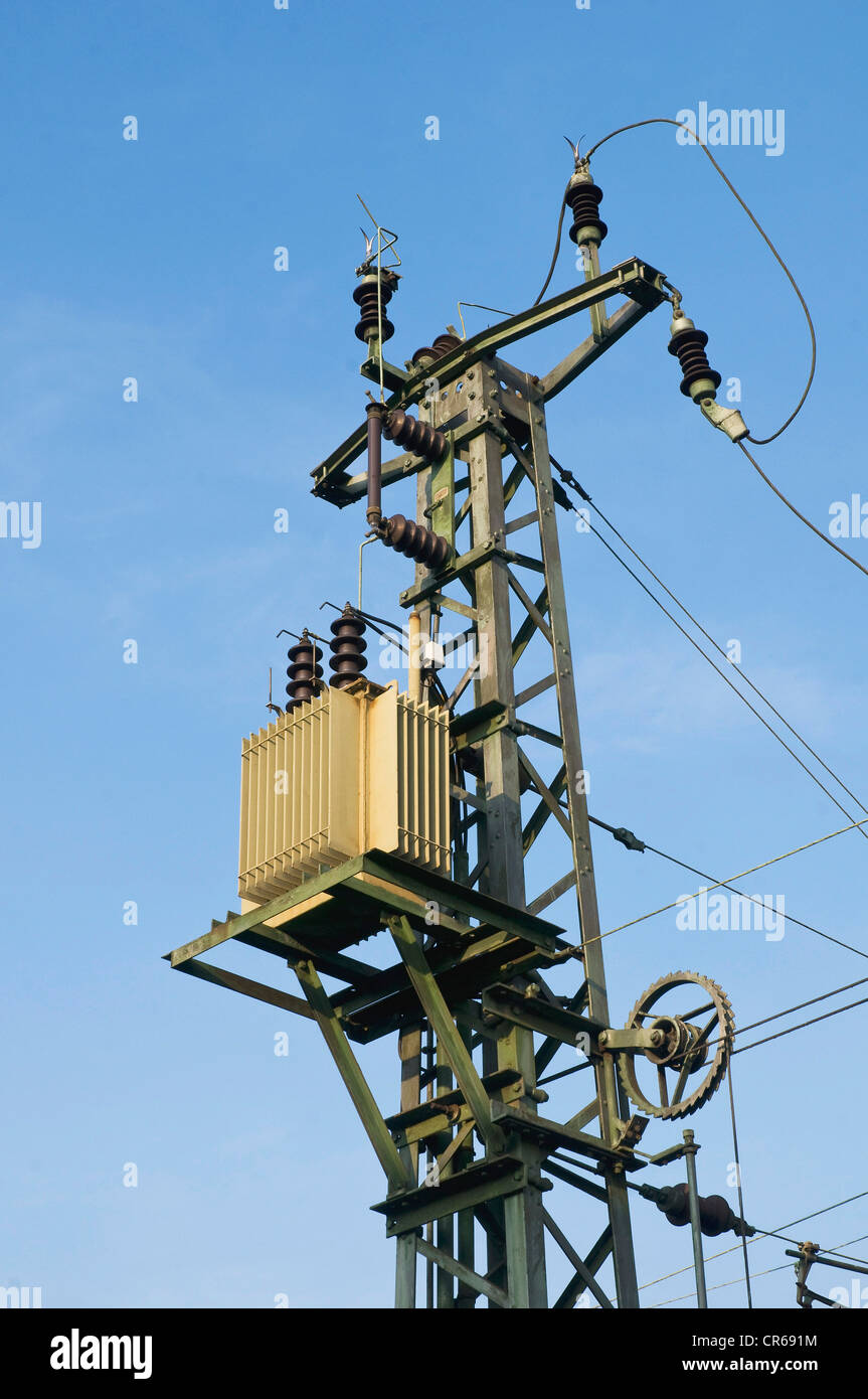 Power supply pylon with a transformer and insulators, with a tension ...
