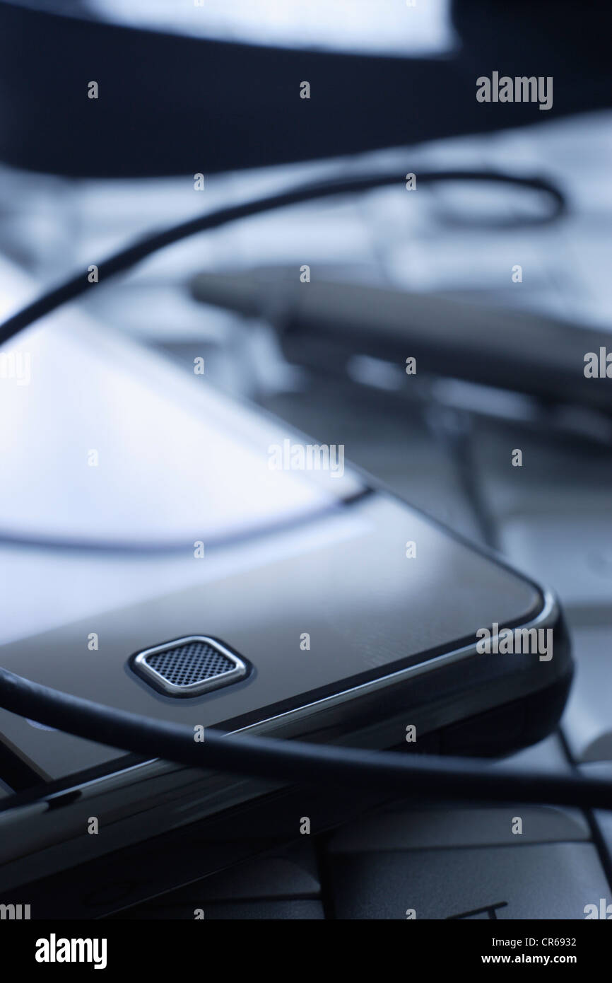 Cell phone on keyboard in office, close up Stock Photo - Alamy