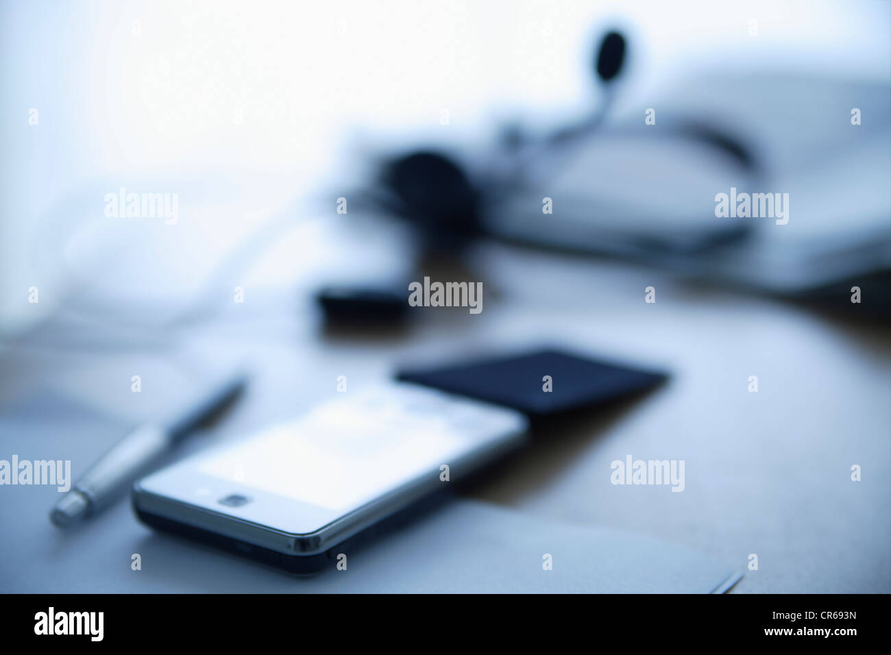 Cell phone, head set and pen on office table, close up Stock Photo - Alamy