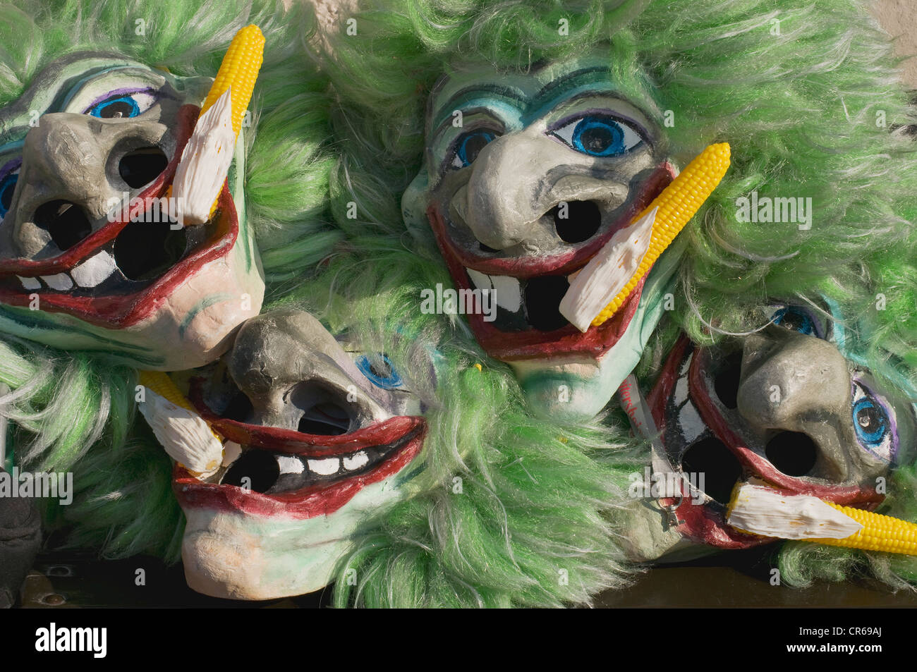 Stacked masks of Gugge traditional musicians, faces with green hair and ...