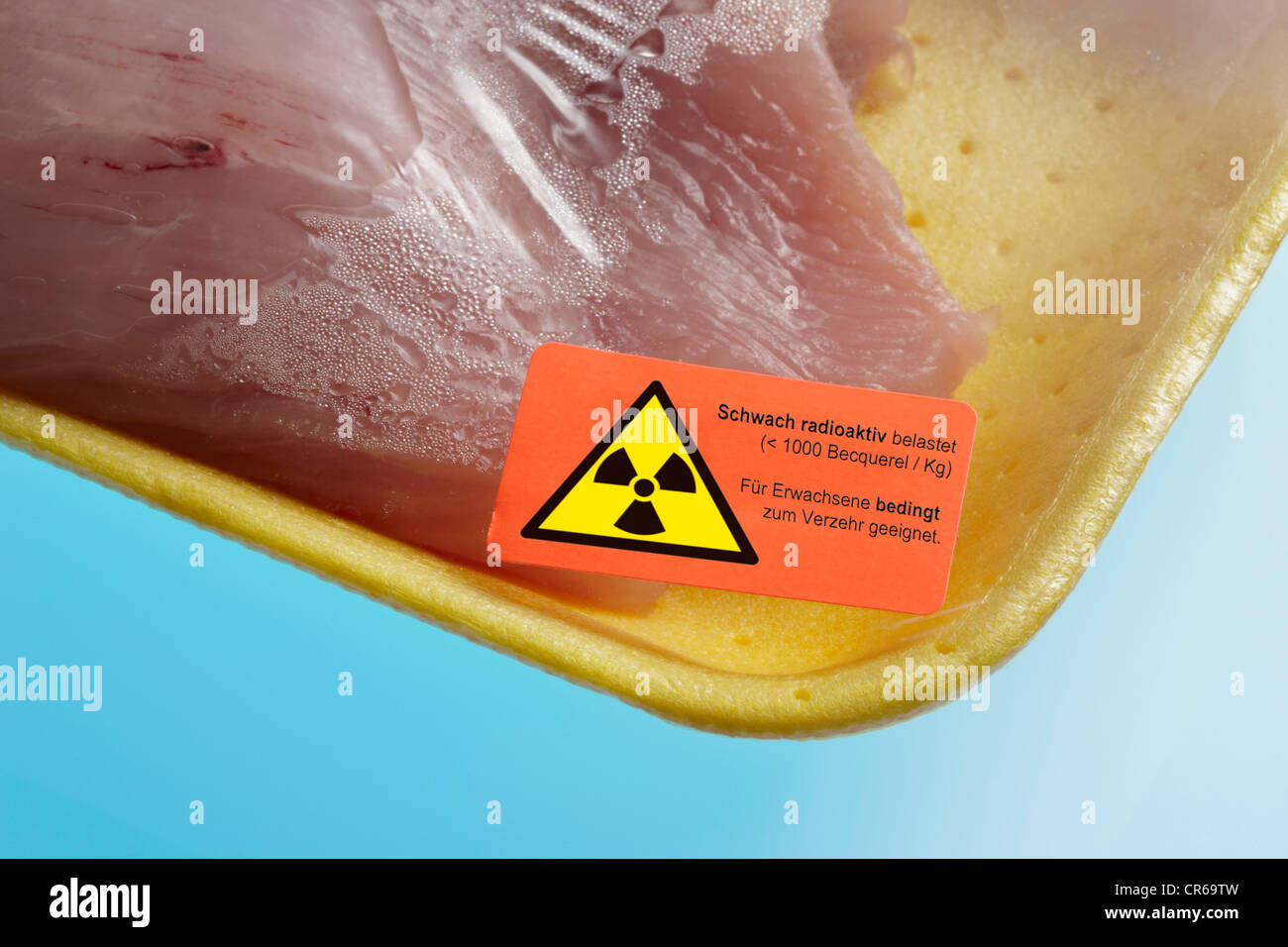 Turkey steaks with radioactive warning sticker on blue background Stock ...