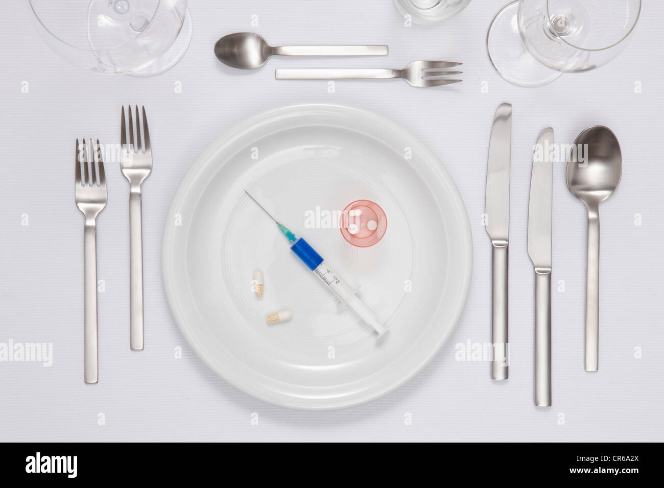 Syringe and tablets in plate Stock Photo - Alamy