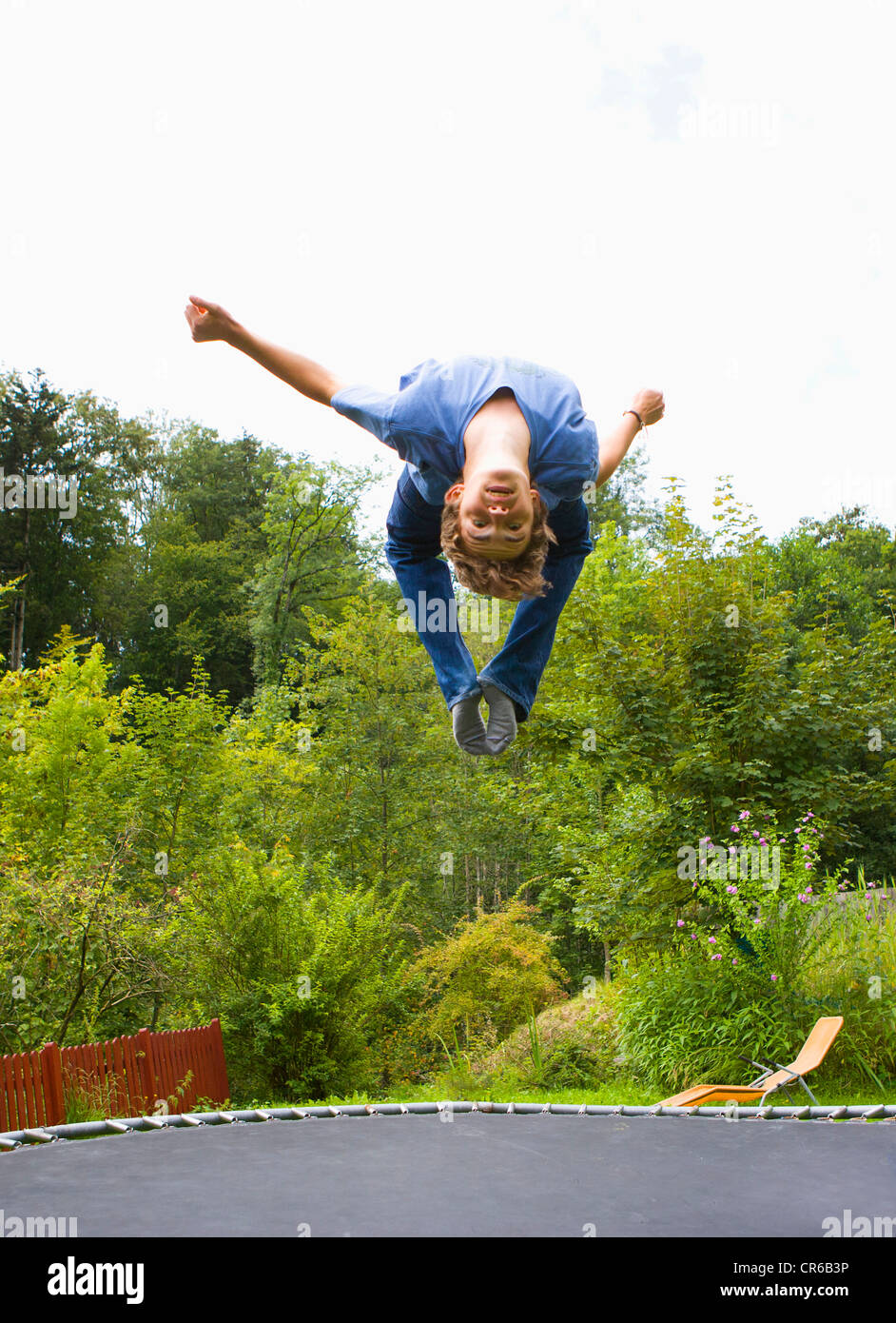 Austria, Young man jumping on trampoline Stock Photo - Alamy