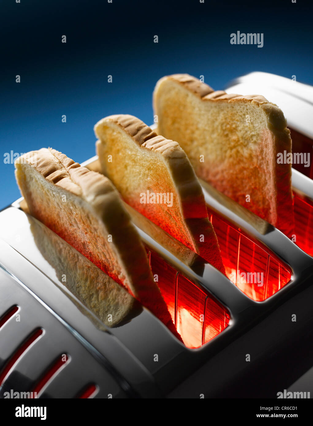 Toast in toaster against blue background Stock Photo - Alamy