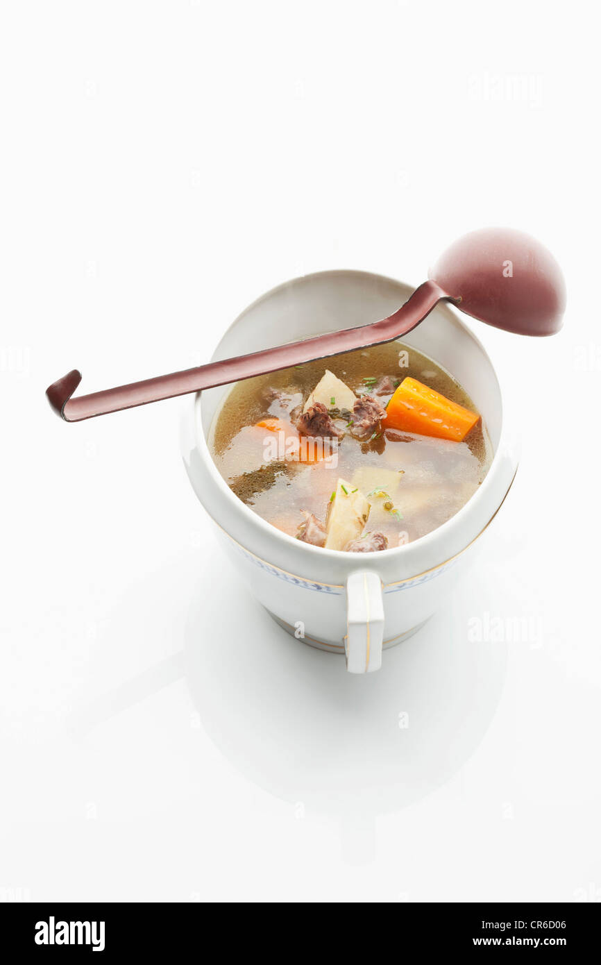 Beef broth in stew pot with ladle on white background Stock Photo - Alamy