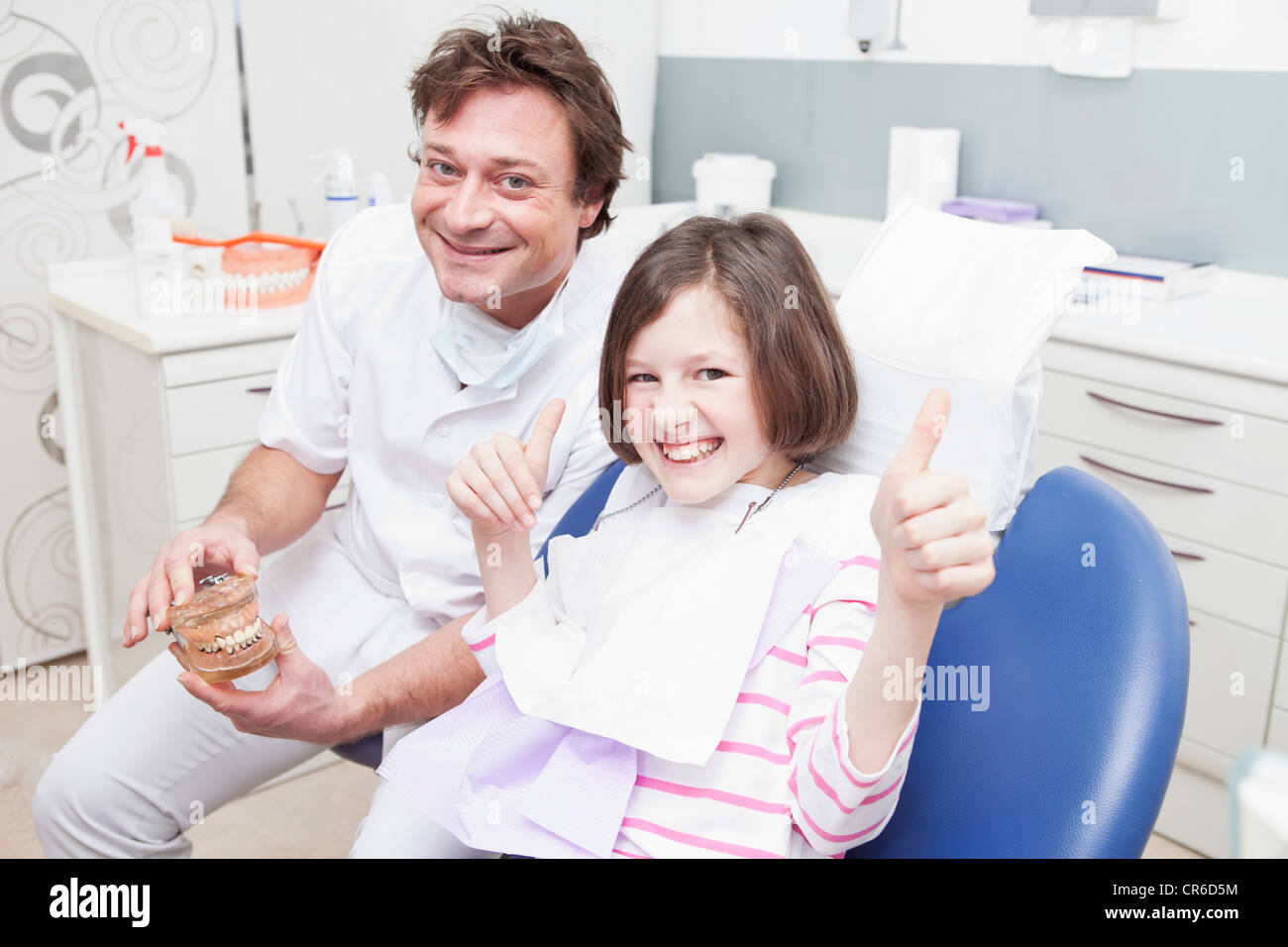 Germany, Bavaria, Patient and doctor with dentures, smiling, portrait ...