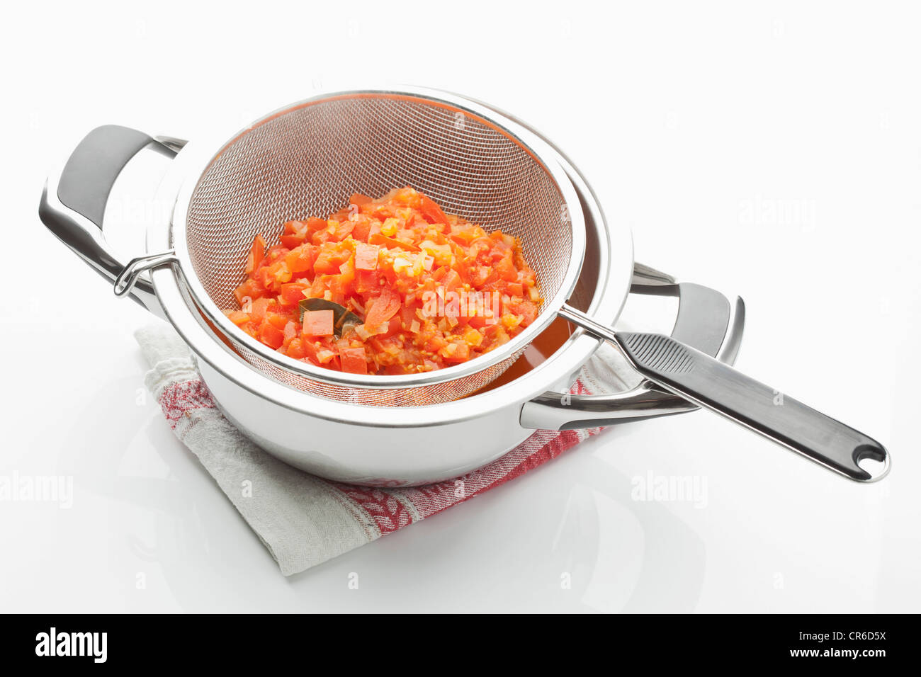 Chopped tomato in sieve with stew pot Stock Photo - Alamy