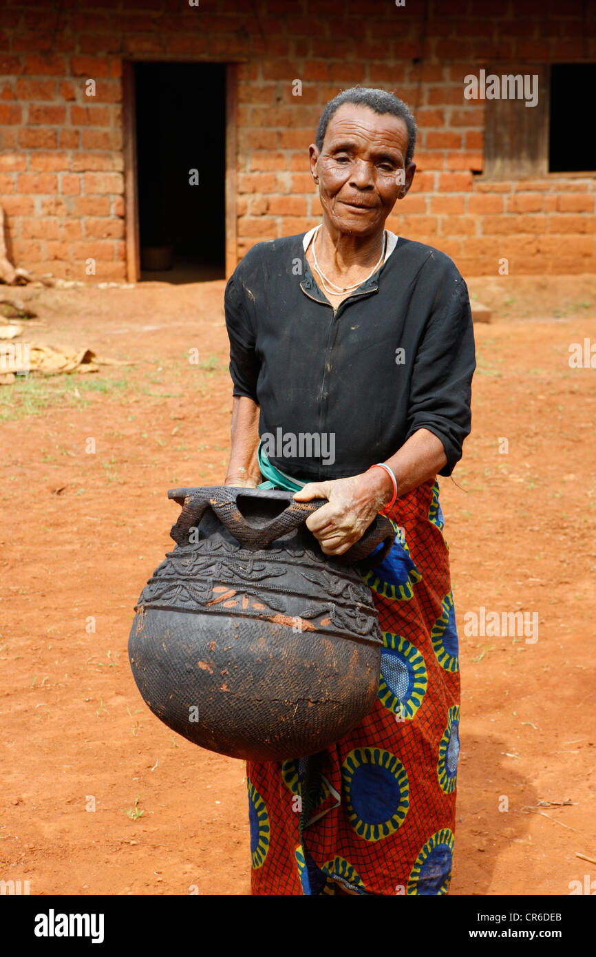 Woman holding an earthenware vessel, production of traditional pottery ...