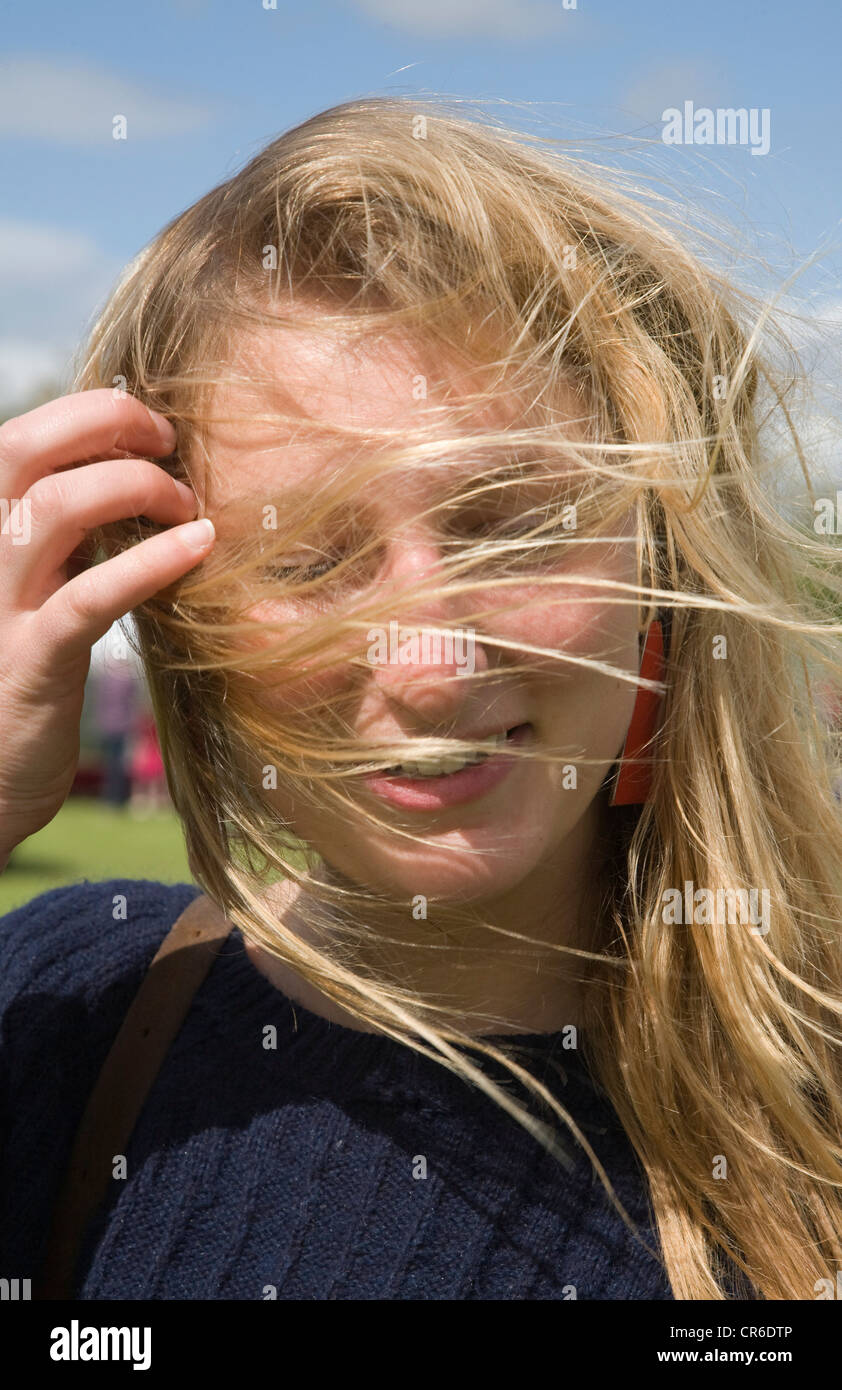Portrait young woman head face shoulders wind blowing hair over face ...