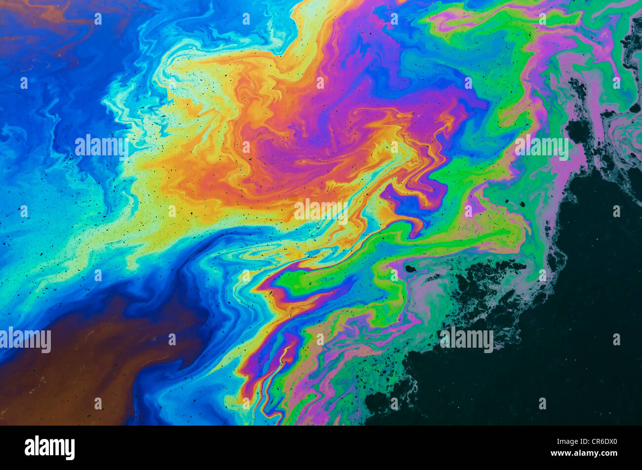 Colorful abstract pattern on surface of water is caused by a fuel spill ...
