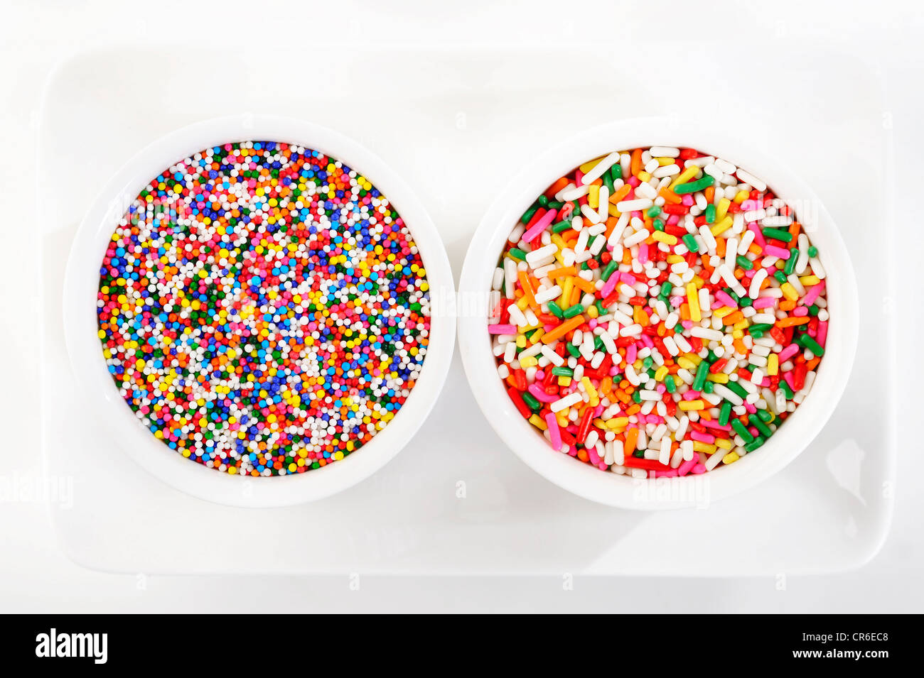 sugar spreading and rainbow sprinkles in cup Stock Photo - Alamy