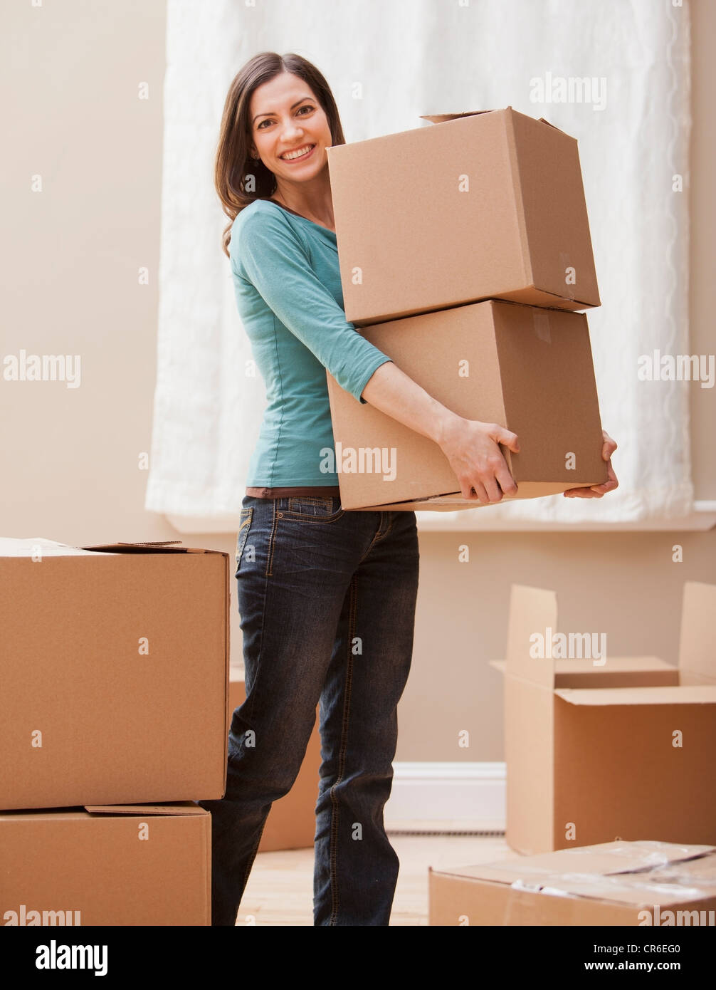 Mid adult woman carrying cardboard boxes Stock Photo - Alamy