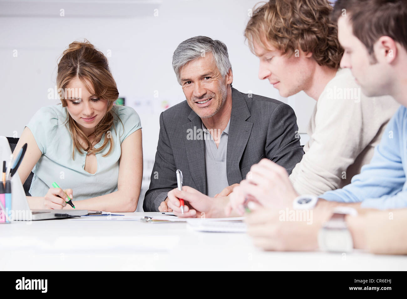 Germany, Bavaria, Munich, Mature man smiling, colleagues working Stock ...