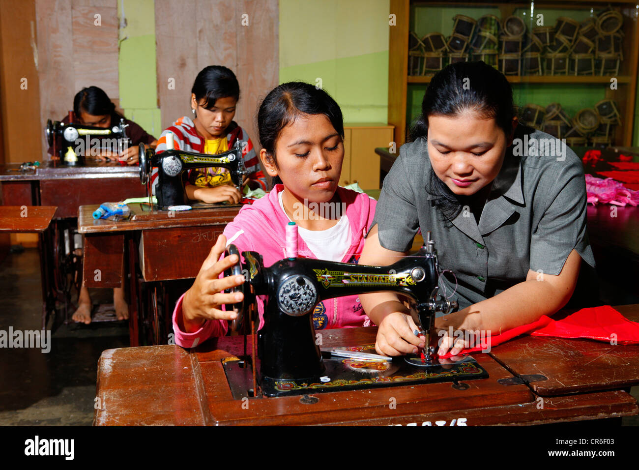 Young woman at the sewing machine during a tailoring apprenticeship ...