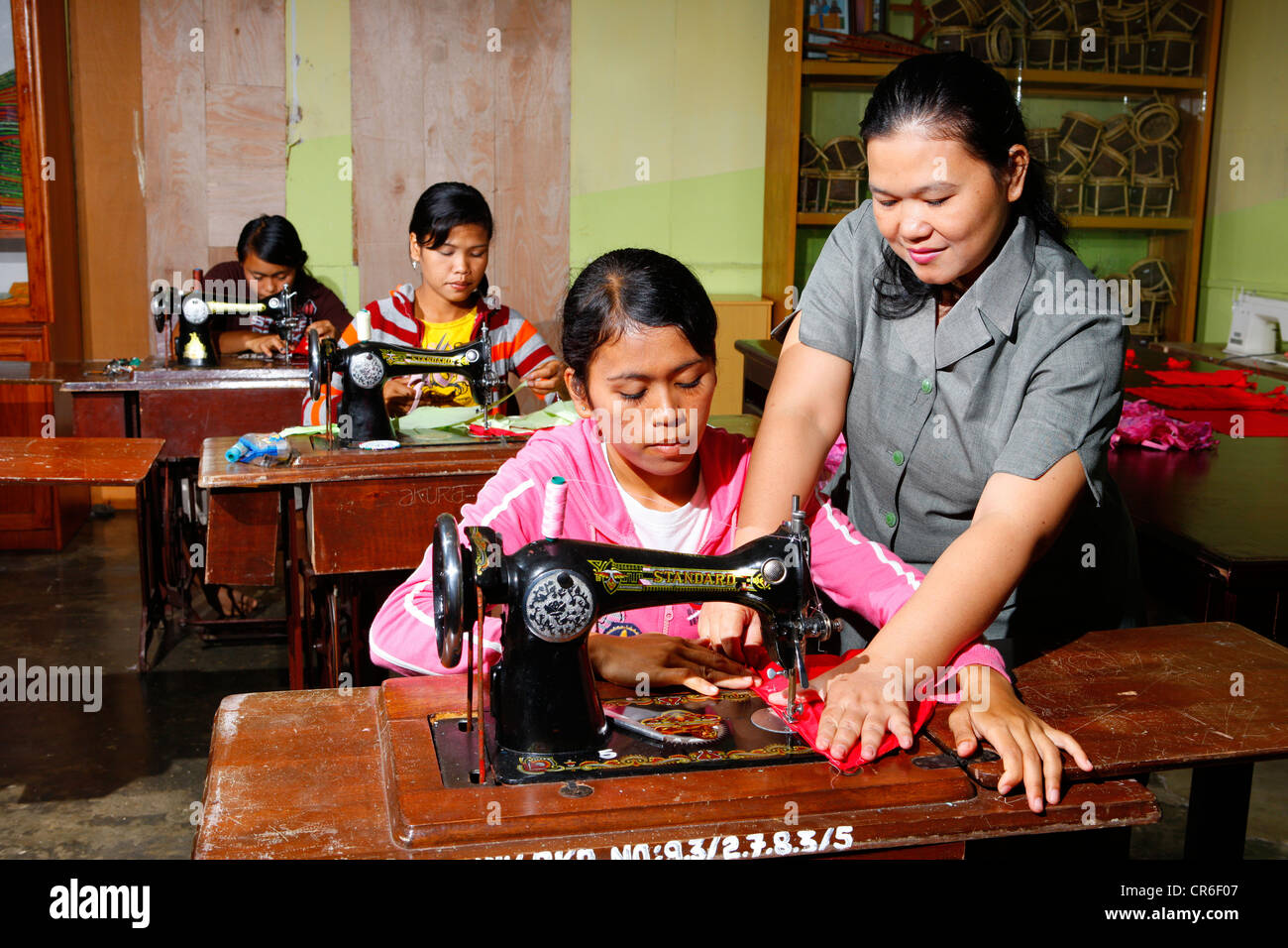 Young woman at the sewing machine during a tailoring apprenticeship ...