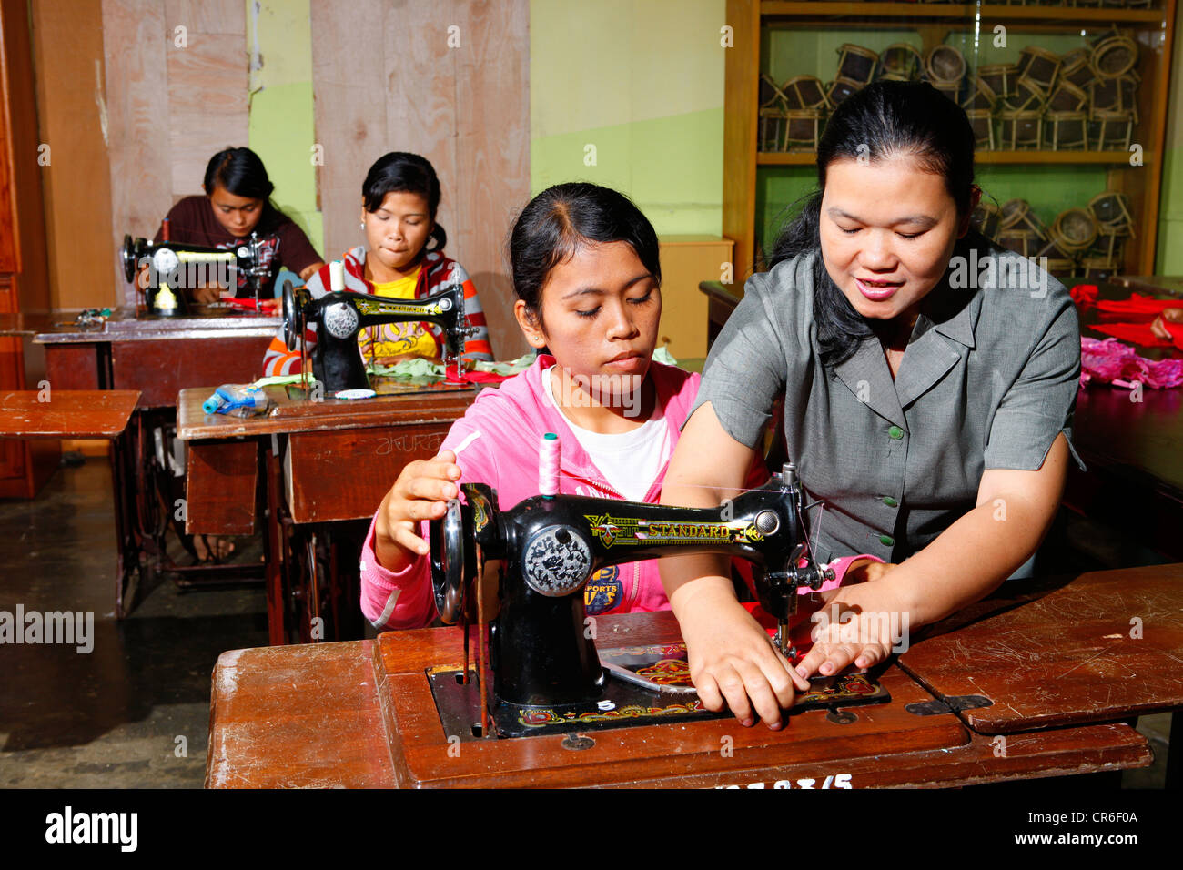 Young woman at the sewing machine during a tailoring apprenticeship ...