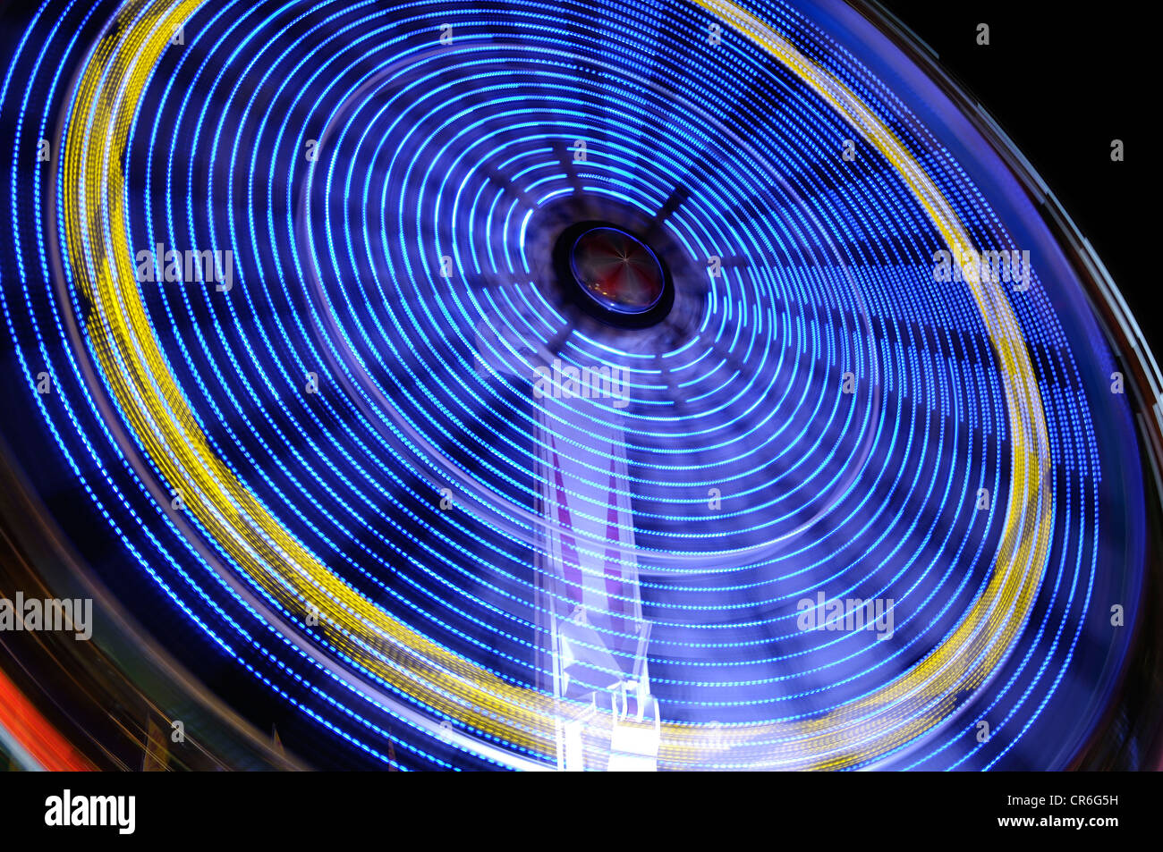 Bright blue illuminated spinning carousel, Oktoberfest 2010, Munich ...