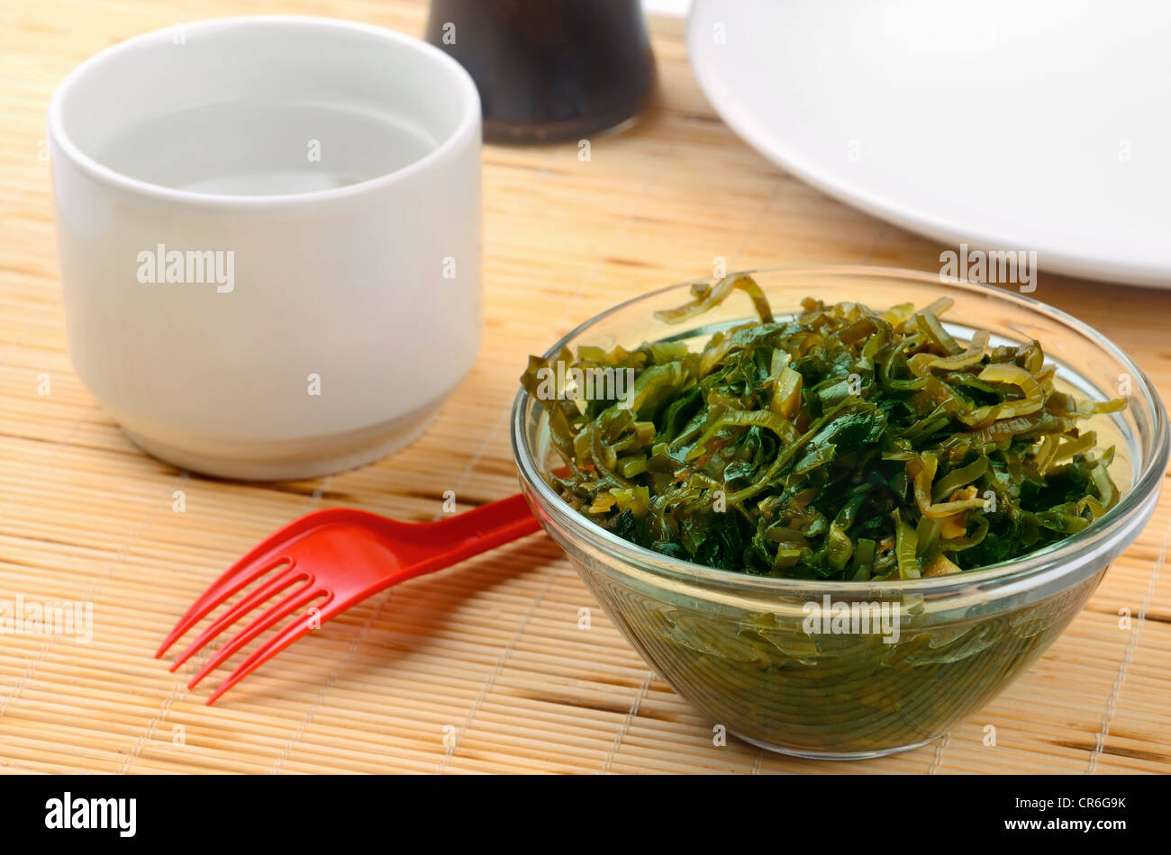 Still life with seaweed salad and cup of water Stock Photo - Alamy