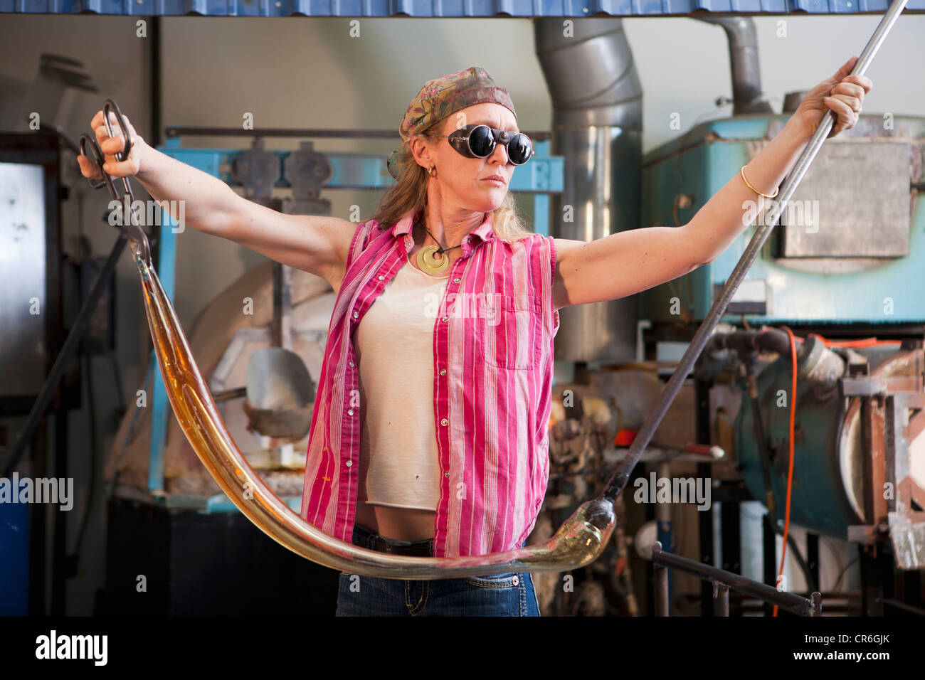 Caucasian woman pulling glass in glass blowing studio Stock Photo - Alamy