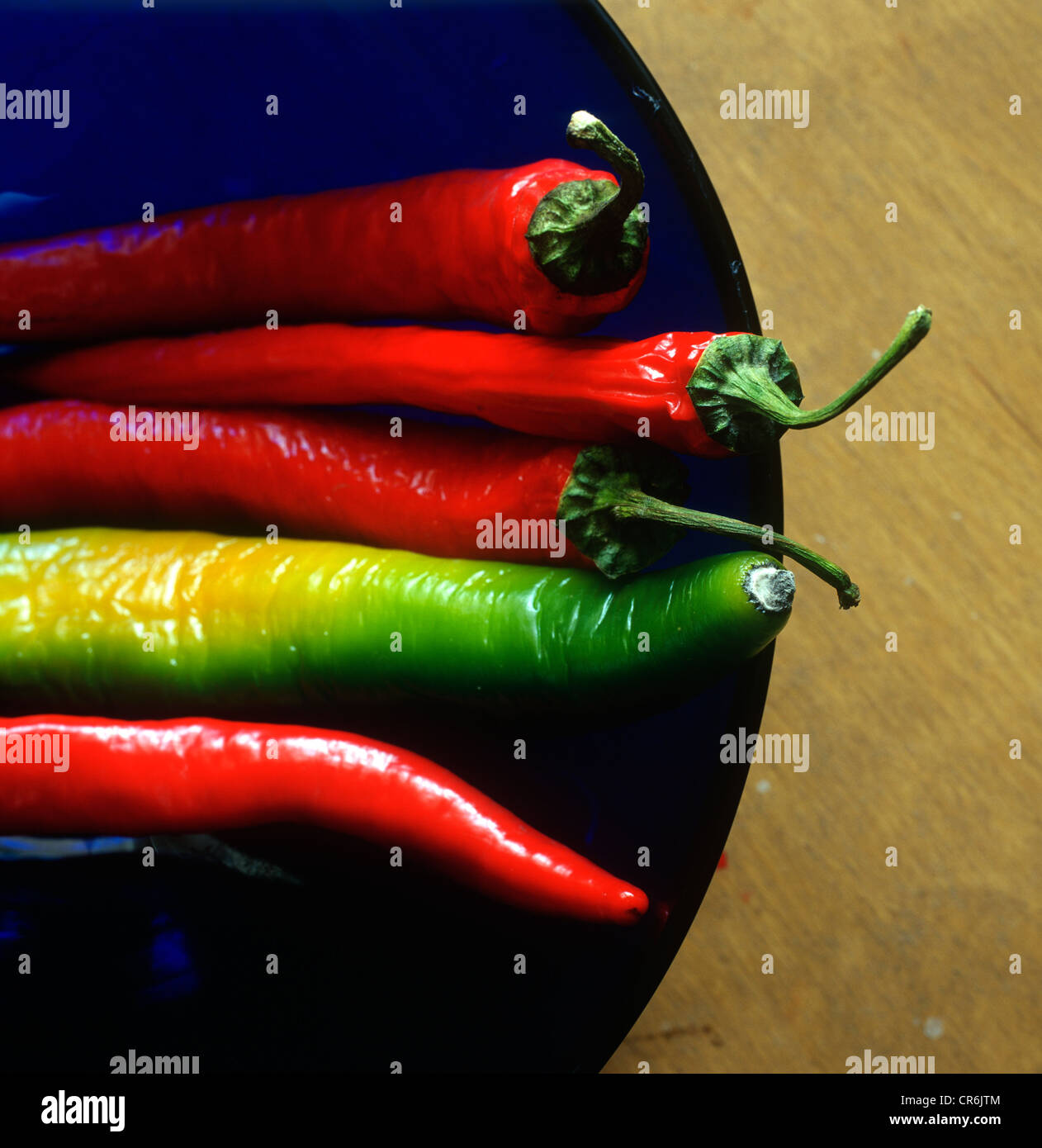 Red and green peppers in a dark blue bowl Stock Photo - Alamy