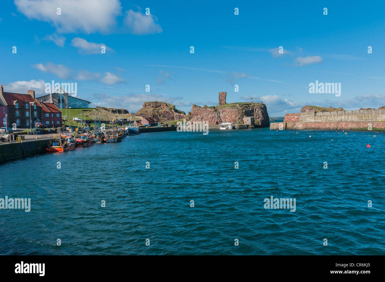 Fishing boats in Dunbar Harbour with Castle Dunbar East Lothian ...