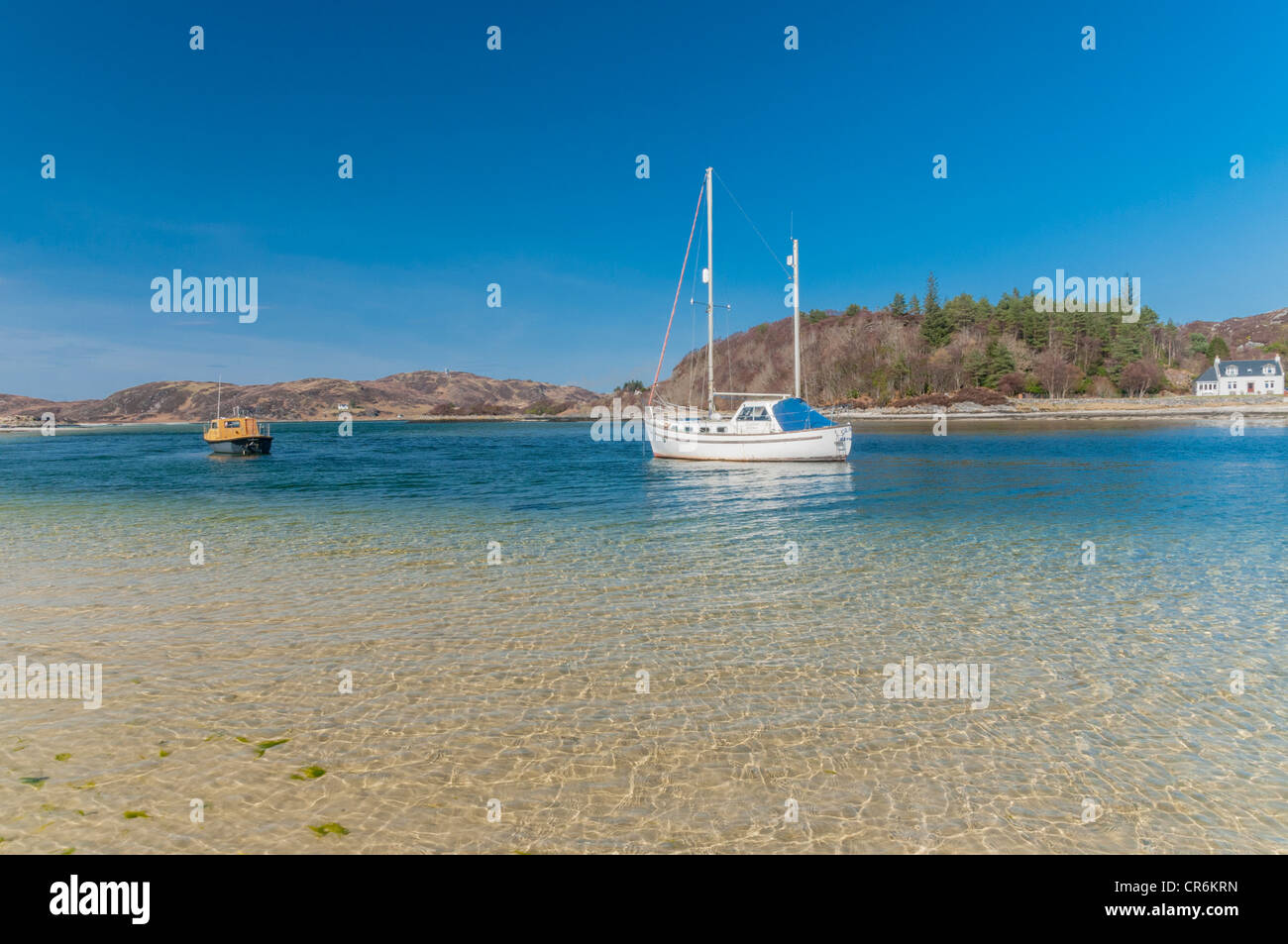 Yacht at white sands of Morar with cottage and road bridge nr Mallaig ...