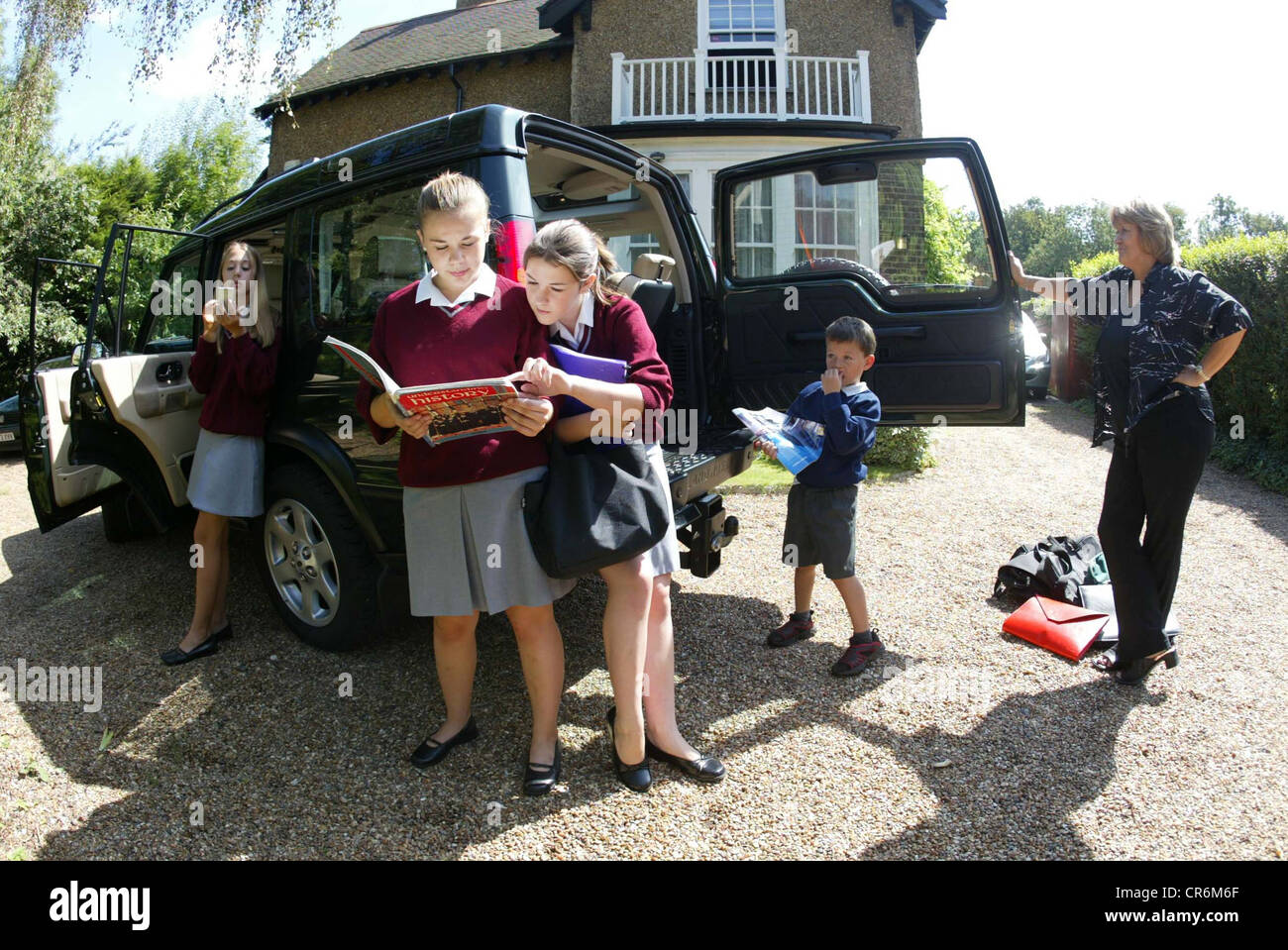 A parent tries to get her children in the car for the morning school ...