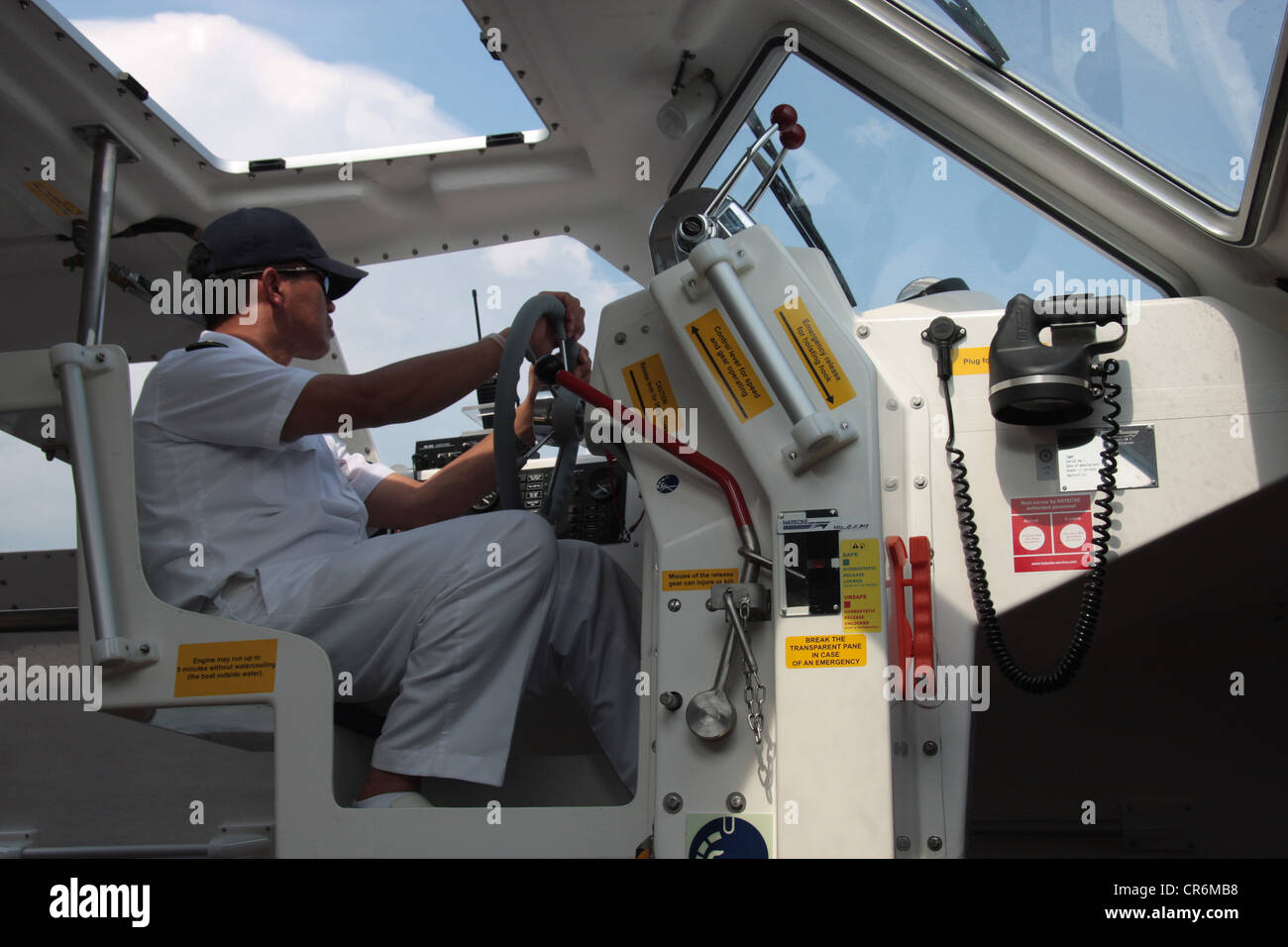 Crewman at the controls of a tender boat from the cruise ship Marina at ...