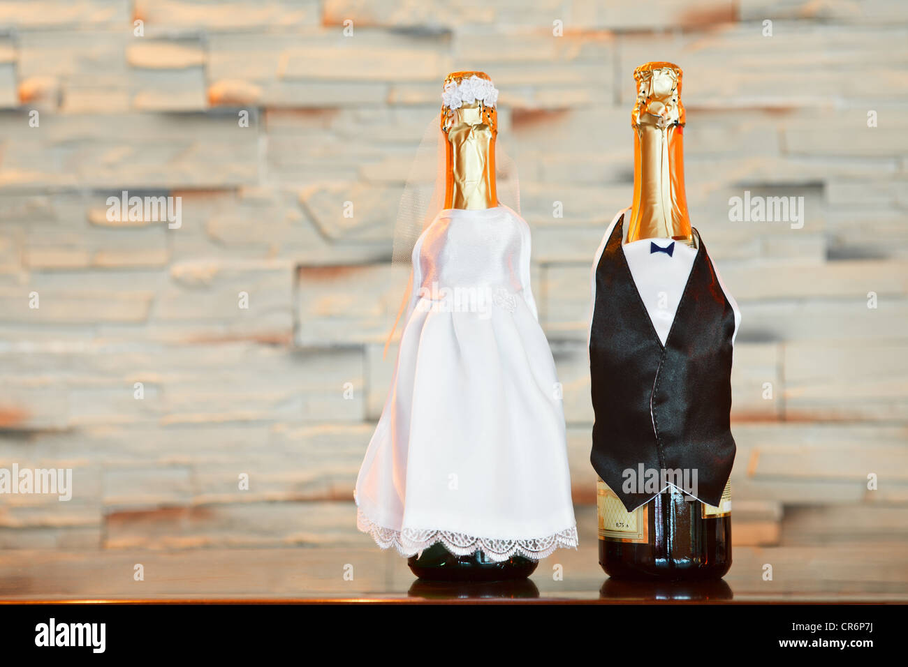 Two bottles of champagne in bride and groom clothes in table. Copy ...