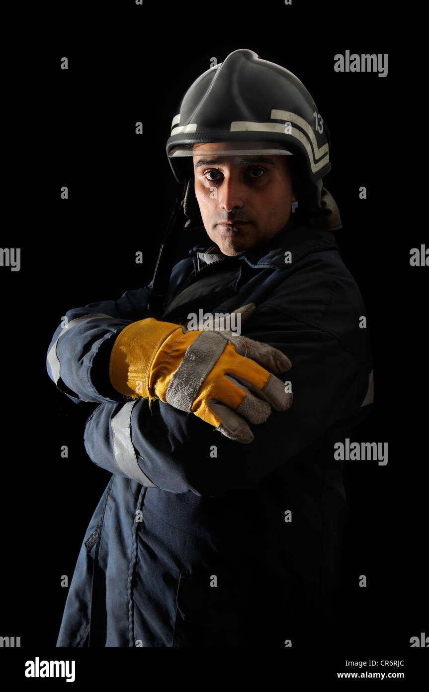 Fireman in uniform isolated in black Stock Photo - Alamy