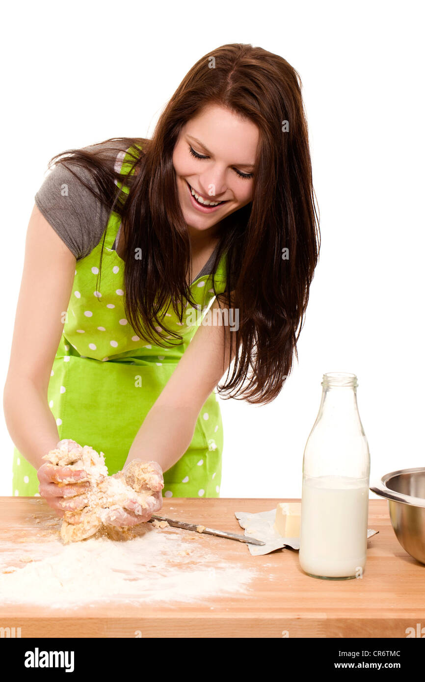 young baking woman forming dough with her hands on white background ...