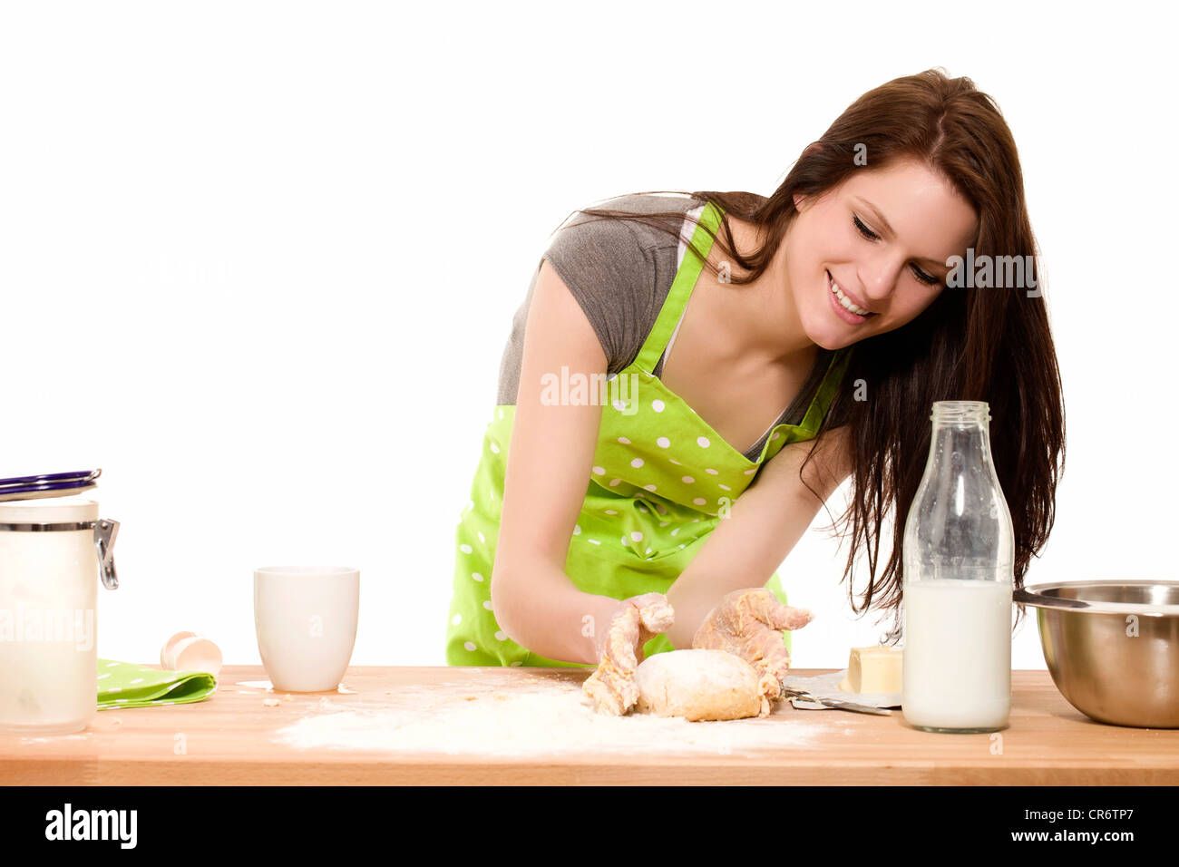 young baking woman forming dough with her hands on white background ...