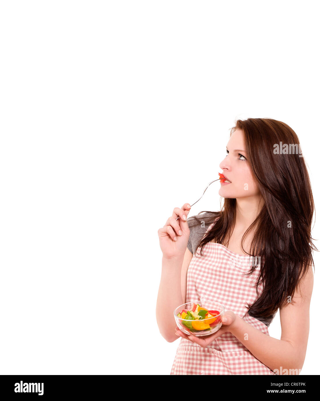 young woman from side eating salad looking up on white background Stock ...